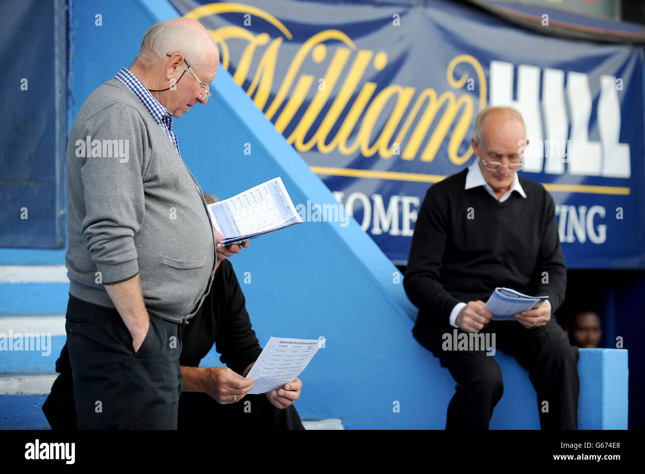 Racegoers look through the race card during the William Hill Derby ...