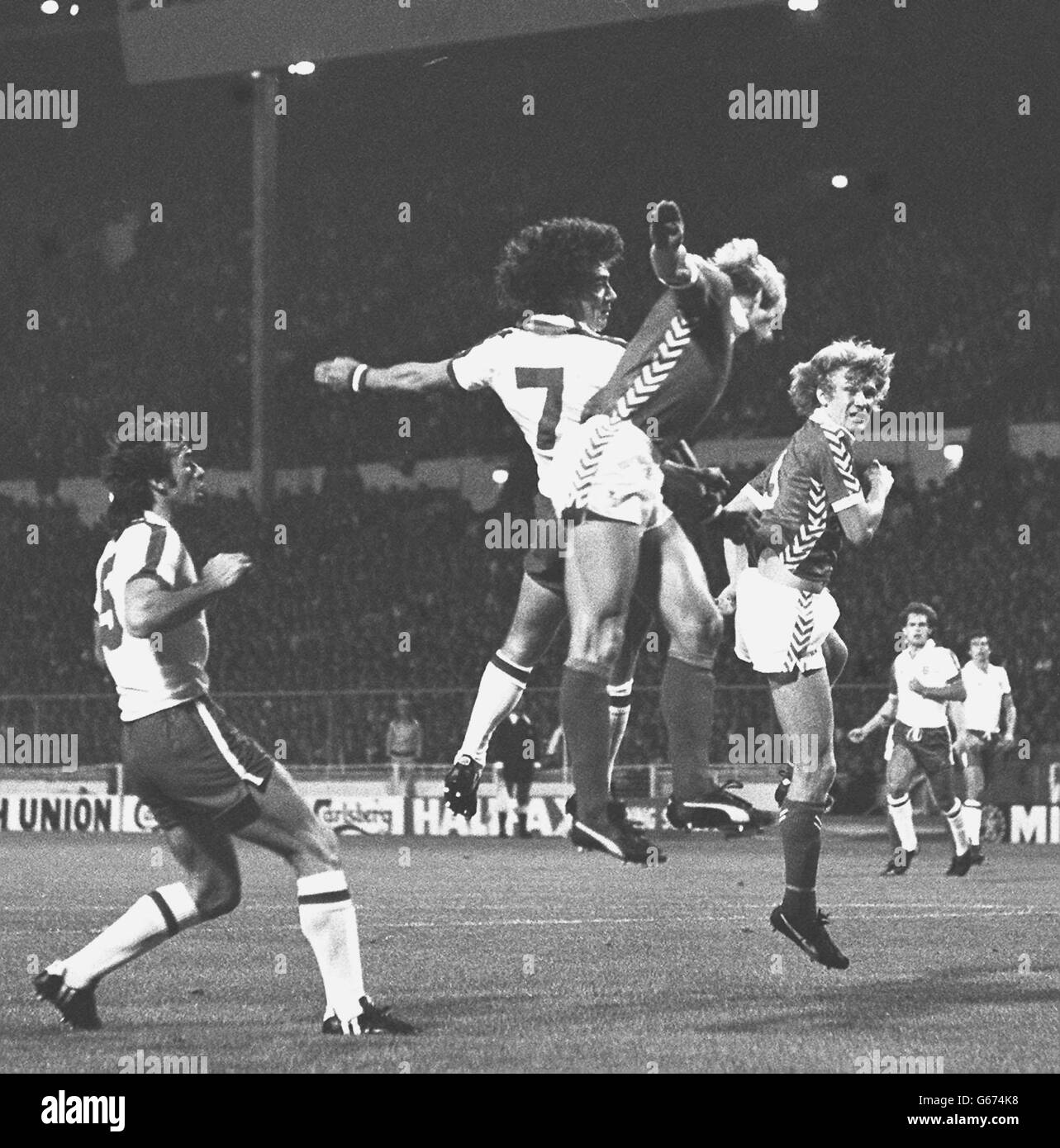 England captain Kevin Keegan (No.7) meets opposition in the air during ...