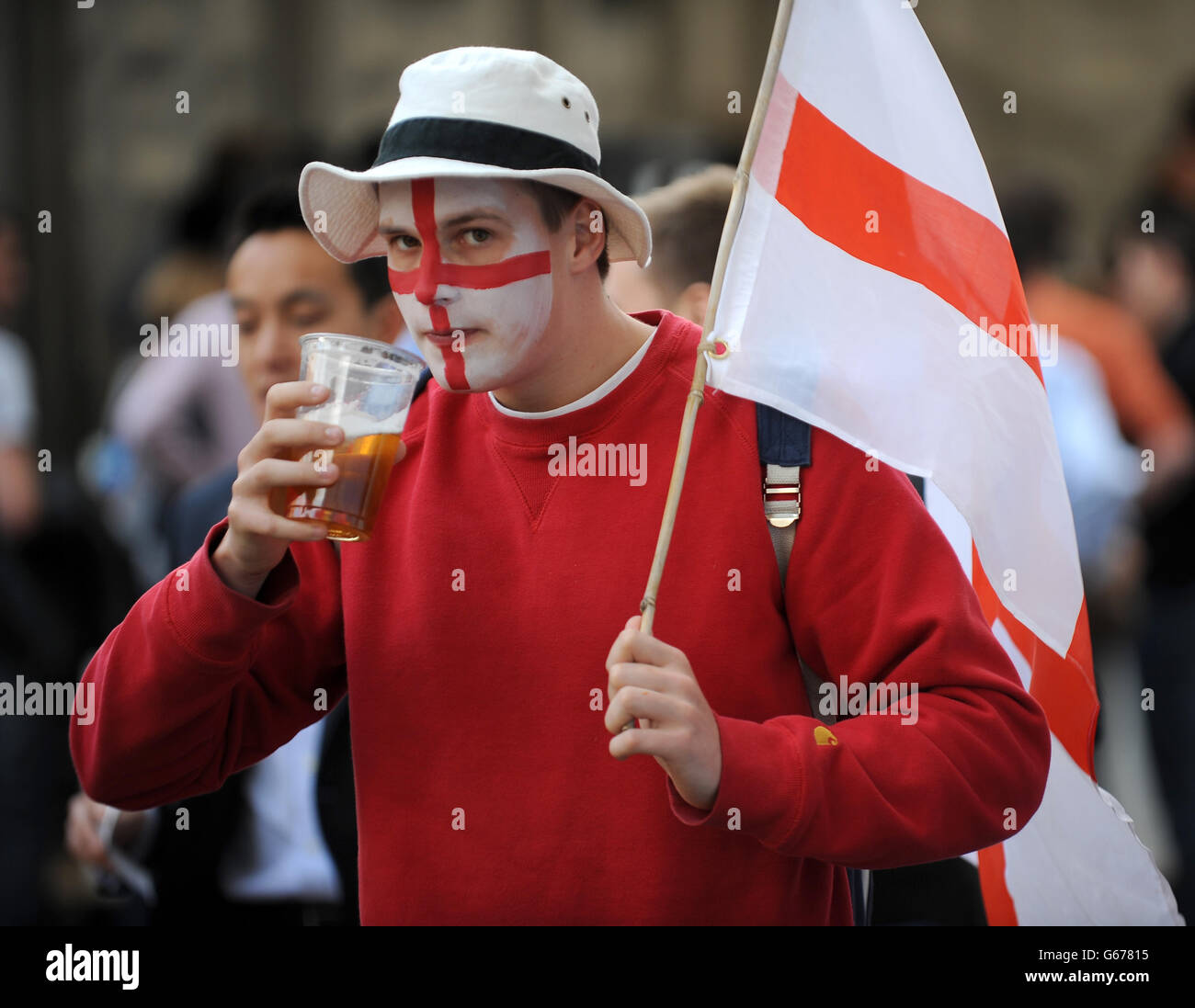 A spectator wearing face paint enjoys a drink before the match Stock ...