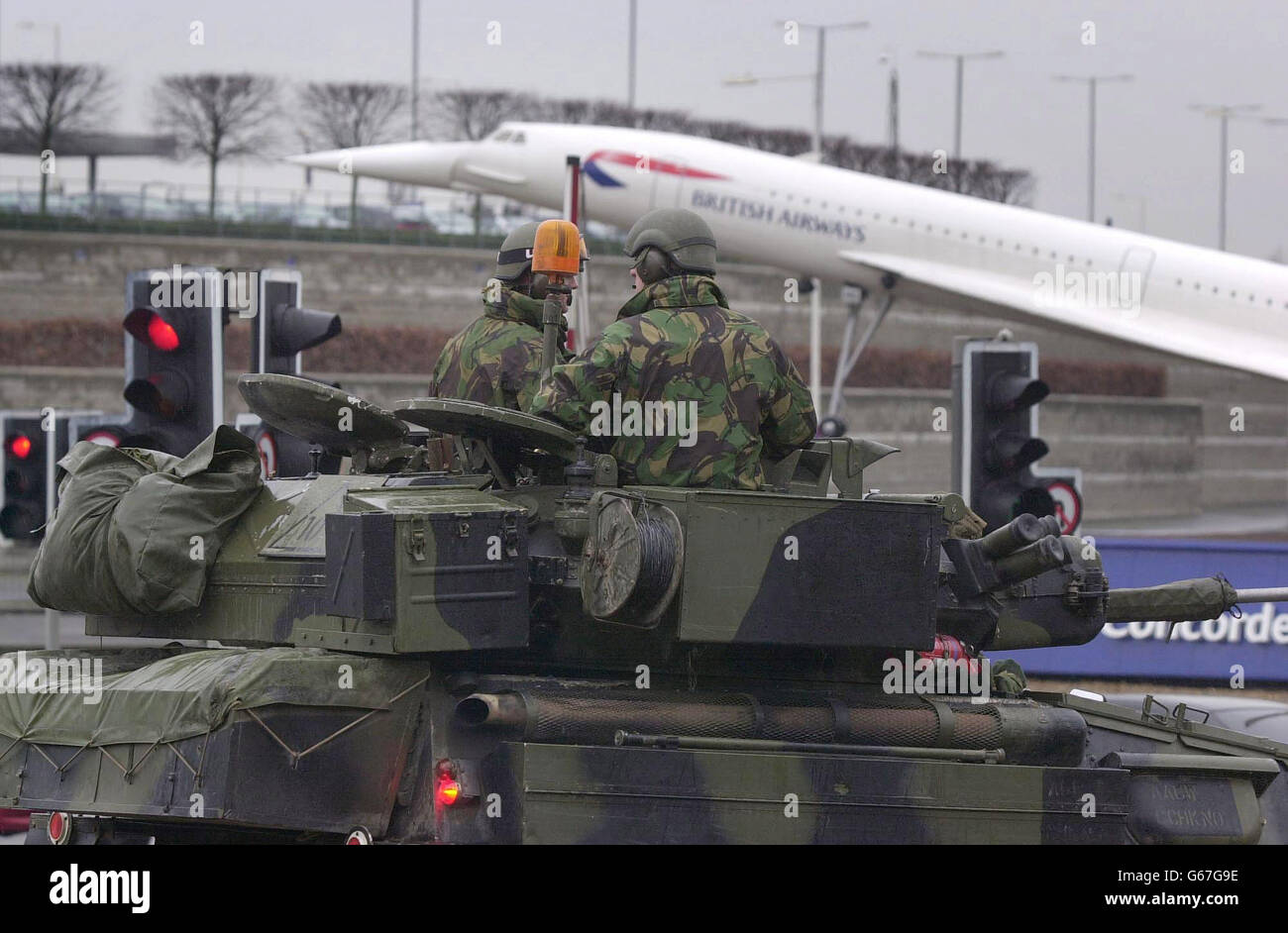 Soldiers in an armoured car stand guard in front of a model of a Britsh ...