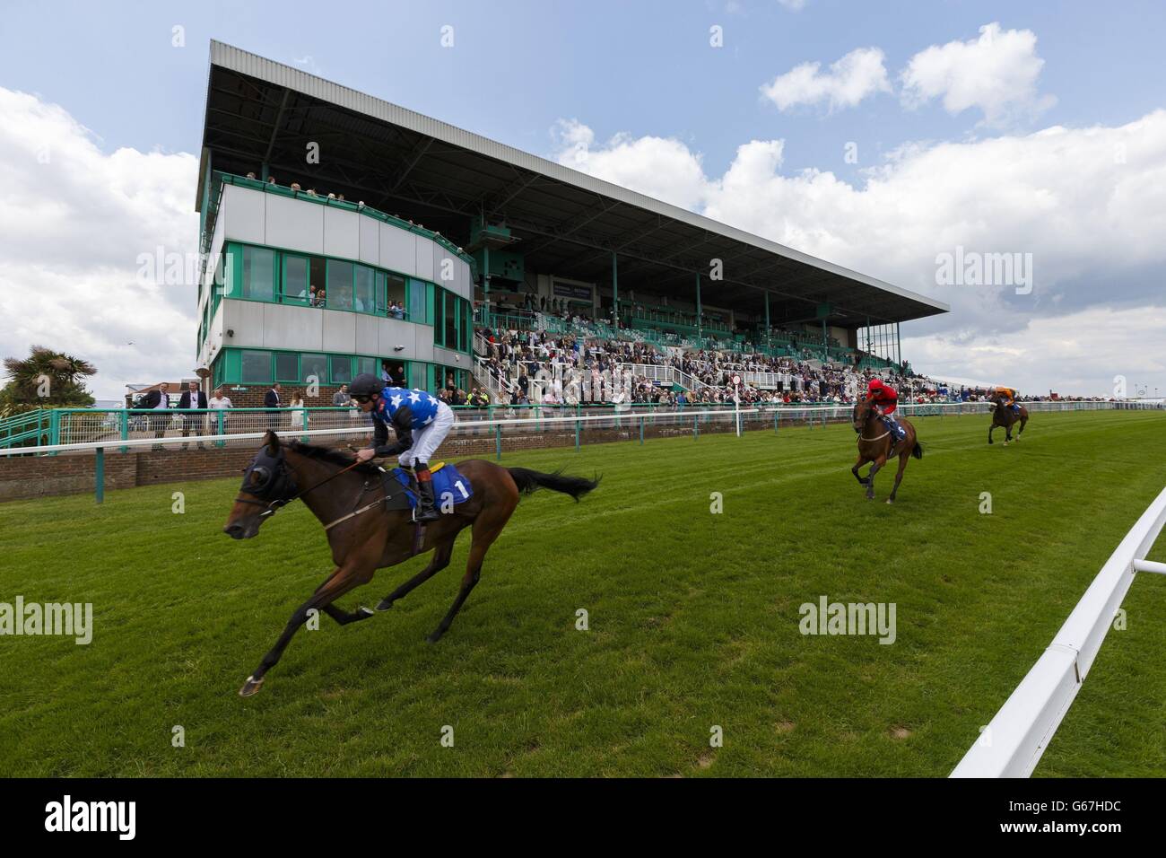 A general view of horses passing the grandstand at Brighton Racecourse ...