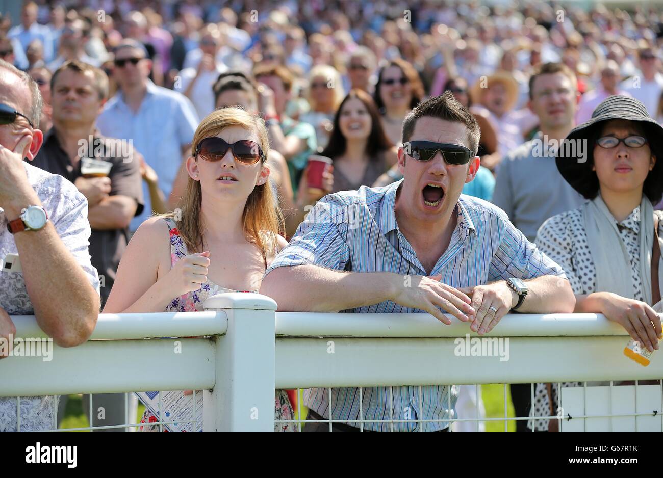 Spectators cheer on the racing from the barrier hi-res stock ...