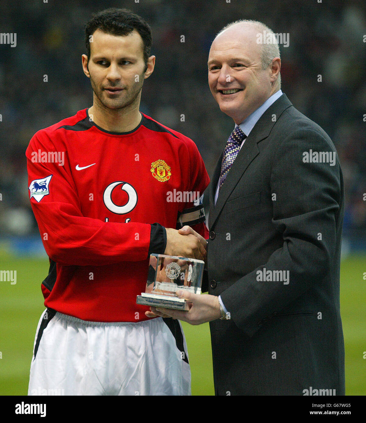Manchester United's Ryan Giggs is presented with a trophy to mark 500 ...