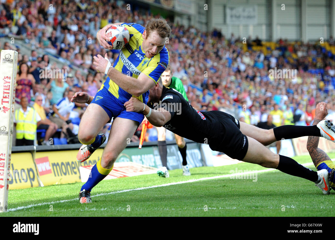 Warrington Wolves' Joel Monaghan goes over for a try past Huddersfield ...