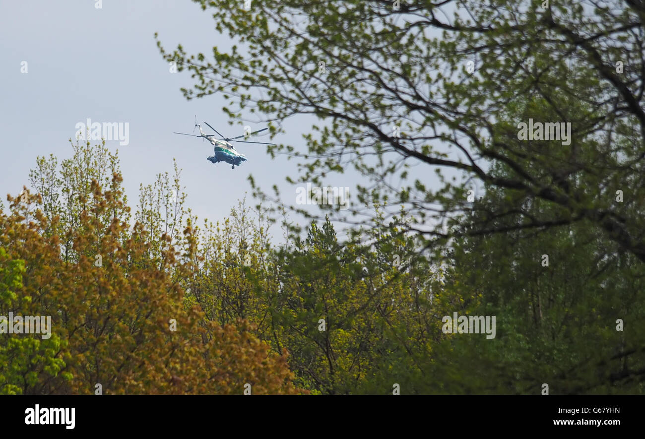 helicopter flies over the forest Stock Photo - Alamy