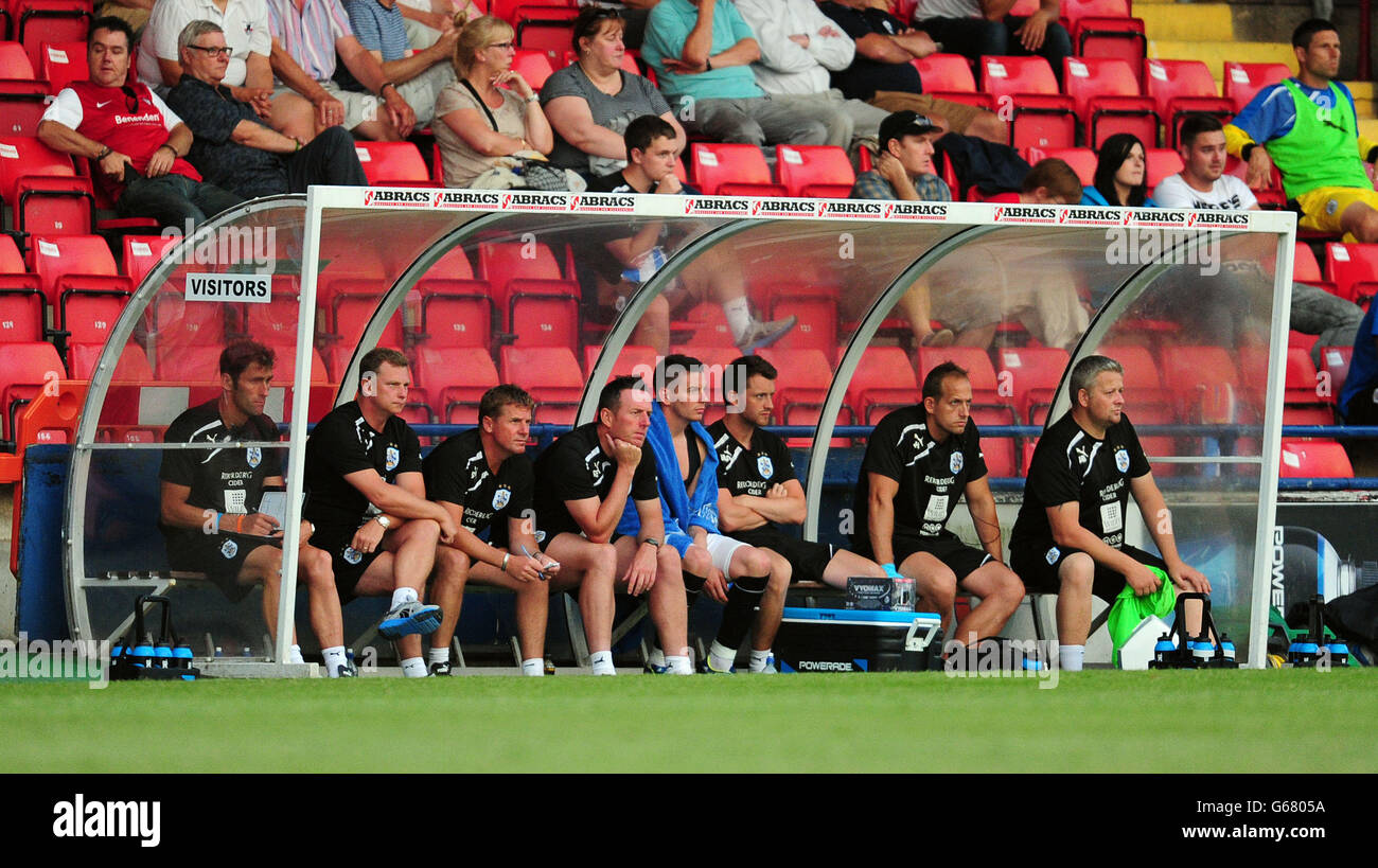 Manager Mark Robins (second left) and the Huddersfield Town bench look ...