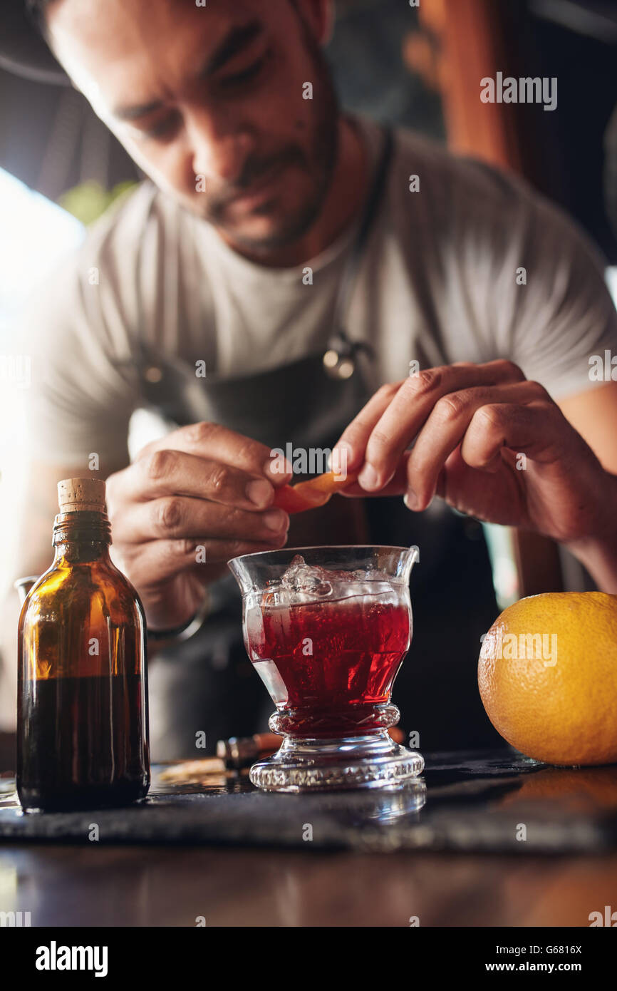 Top view of bartender hands garnishing negroni cocktail on the counter ...