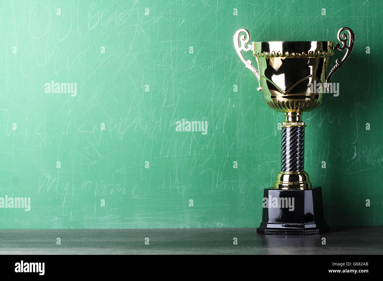 winning trophy with green calkboard background Stock Photo - Alamy