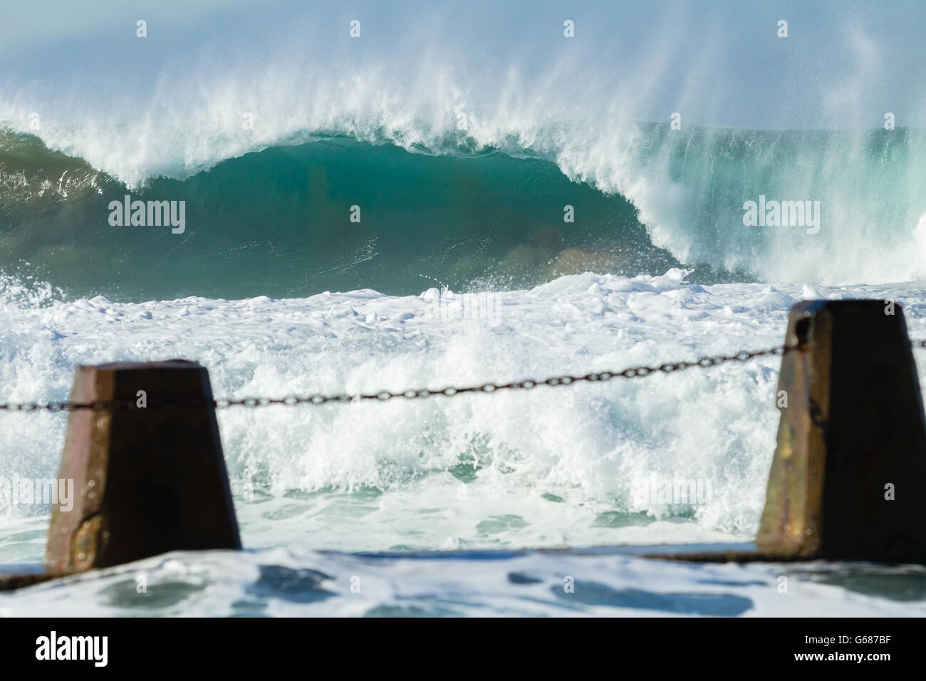 Ocean wave closeup crashing wall of blue water front of swimming beach ...
