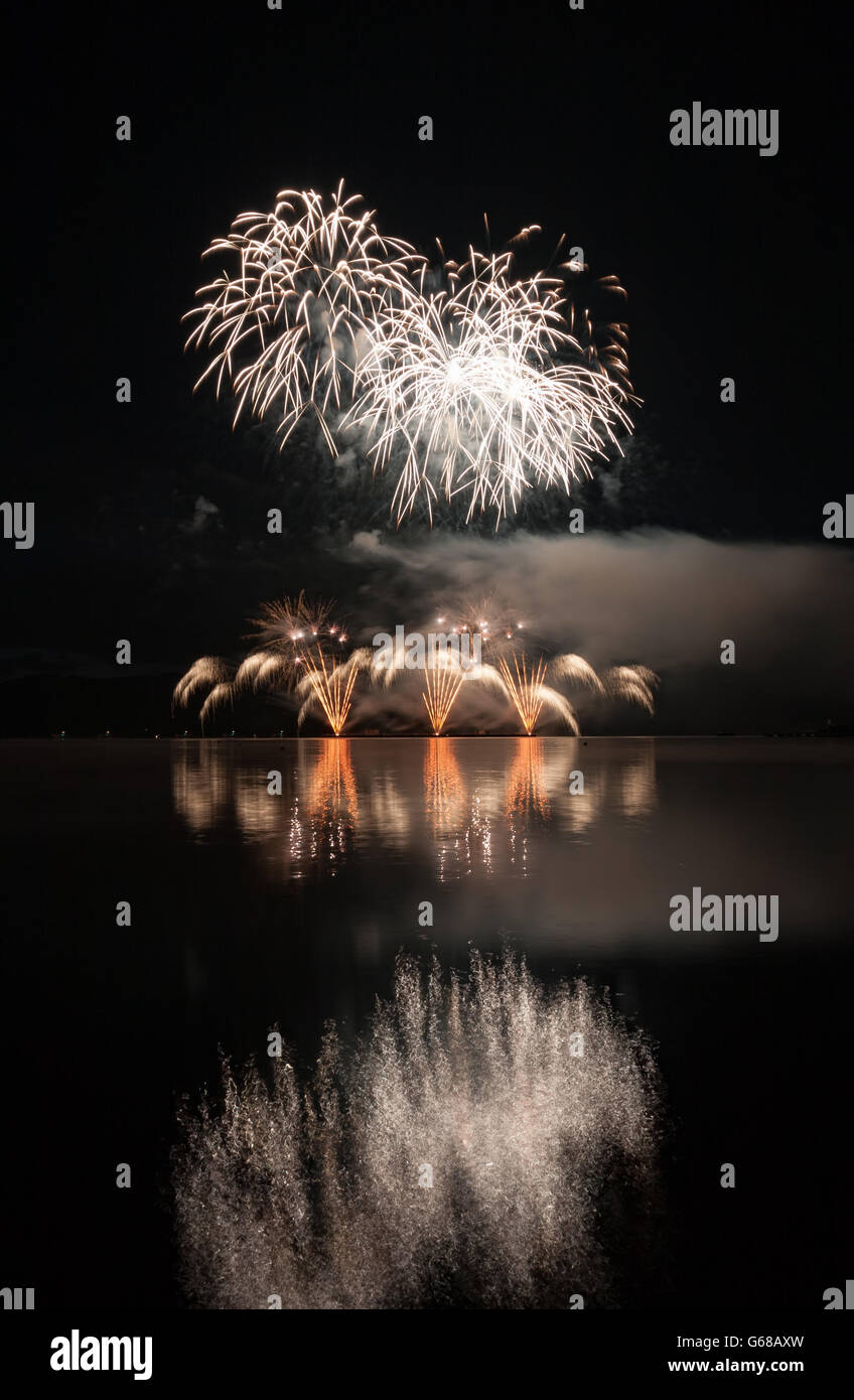 Colorful fireworks with reflection on lake and night sky in background ...
