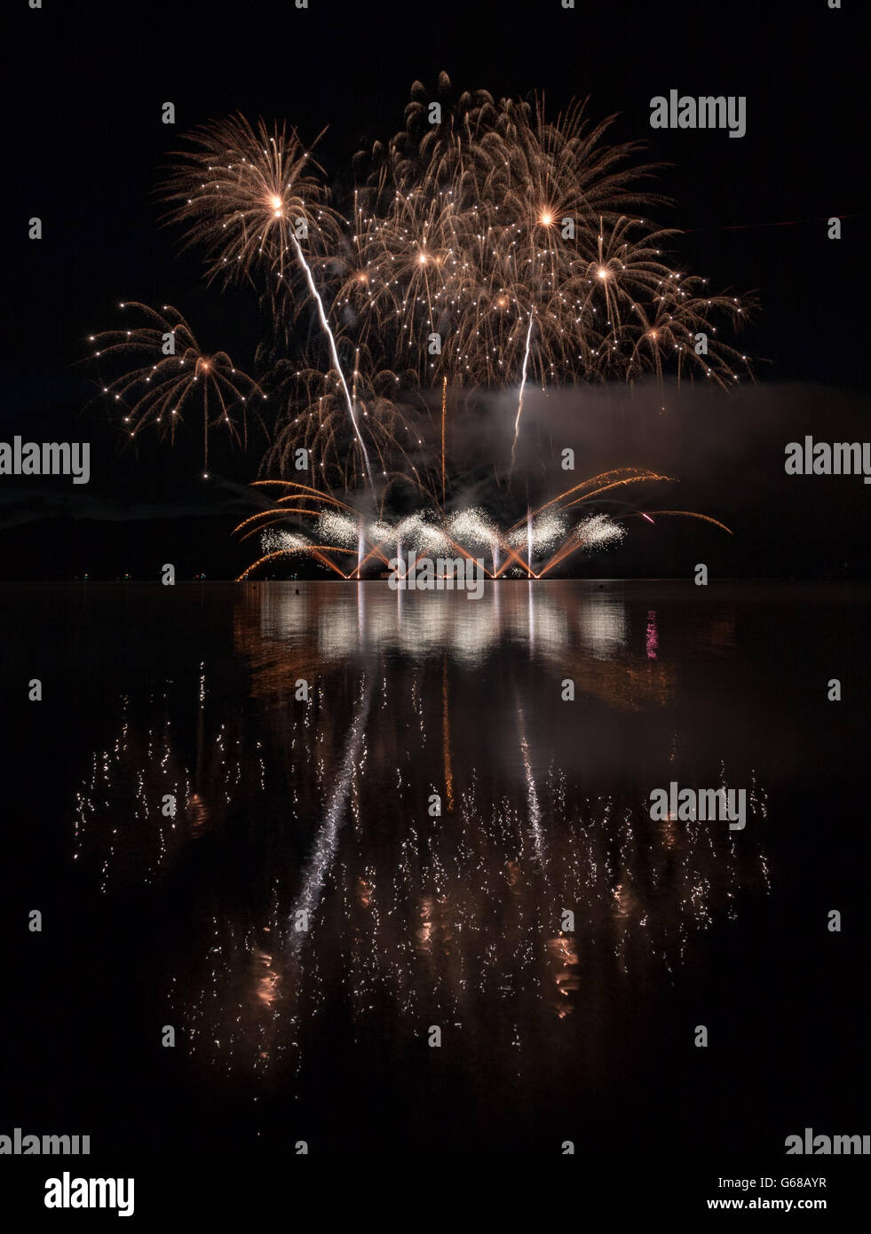Colorful fireworks with reflection on lake and night sky in background ...