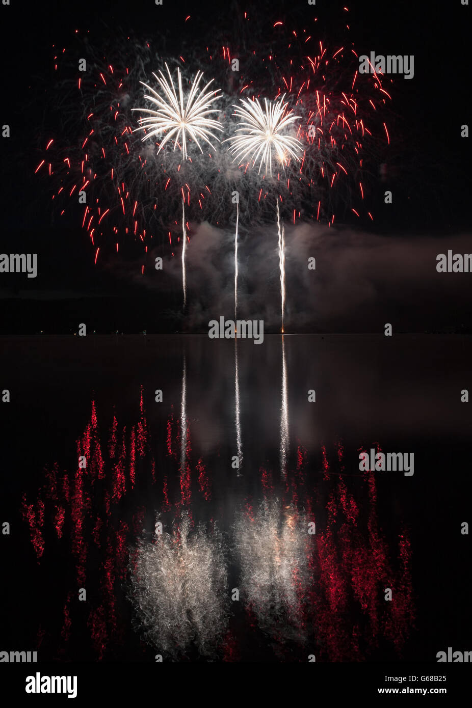 Colorful fireworks with reflection on lake and night sky in background ...