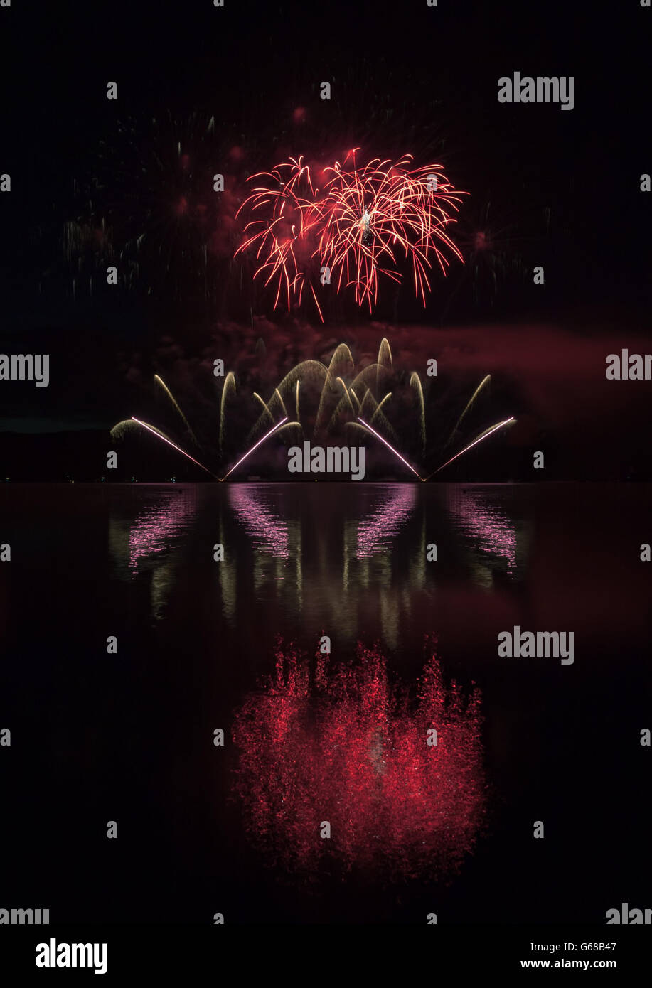 Colorful fireworks with reflection on lake and night sky in background ...