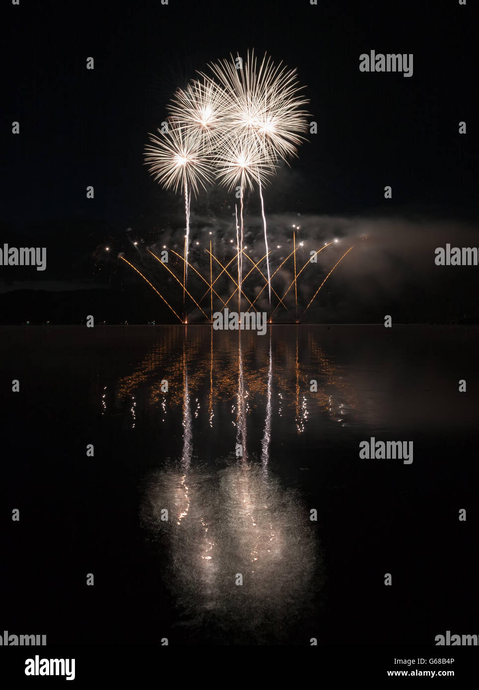Colorful fireworks with reflection on lake and night sky in background ...
