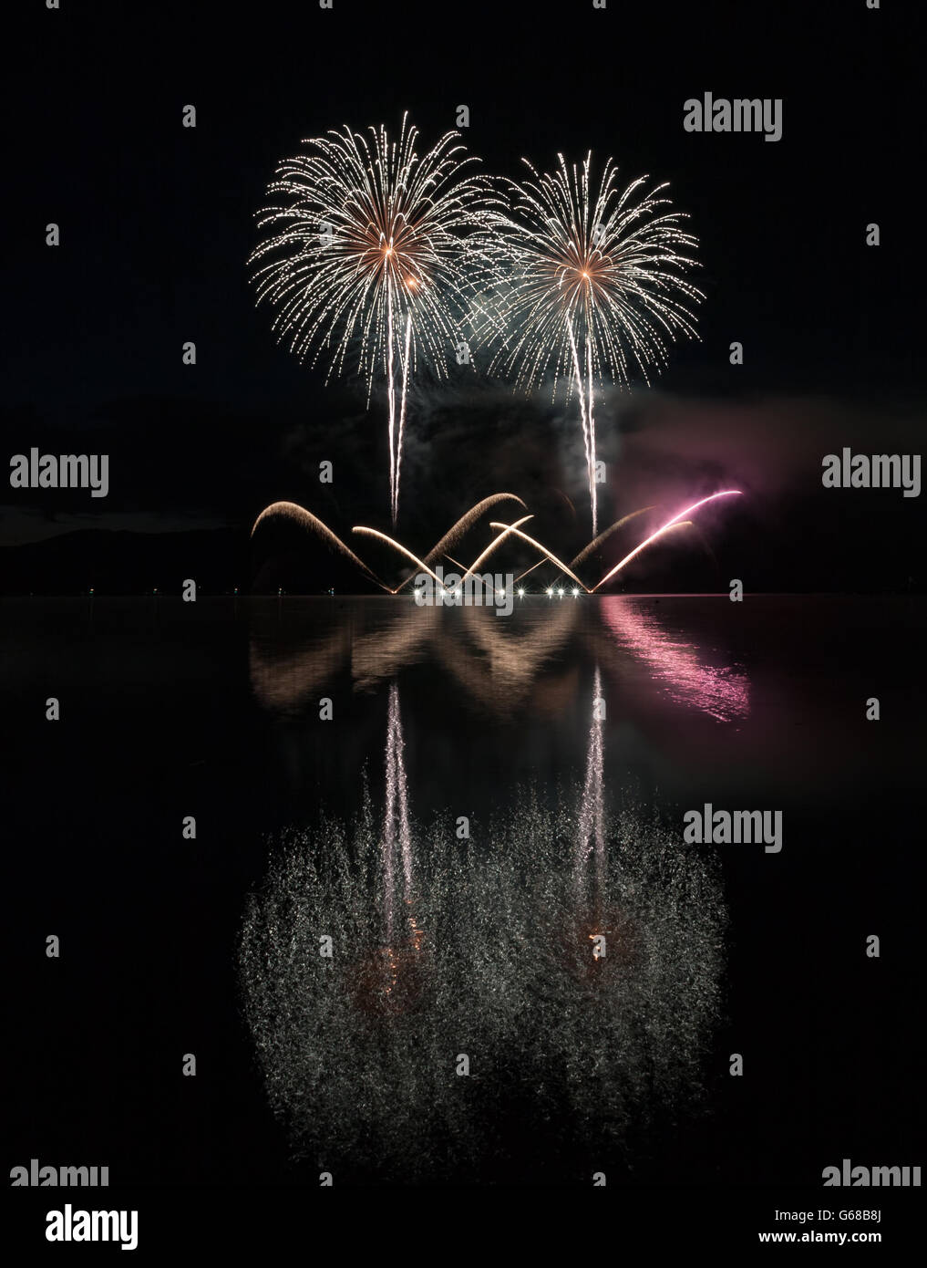 Colorful fireworks with reflection on lake and night sky in background ...