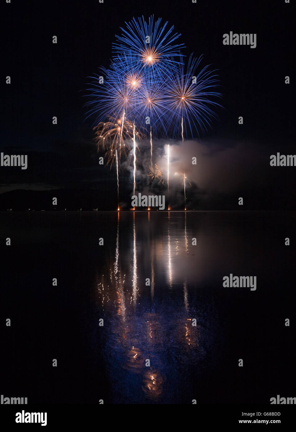 Colorful fireworks with reflection on lake and night sky in background ...