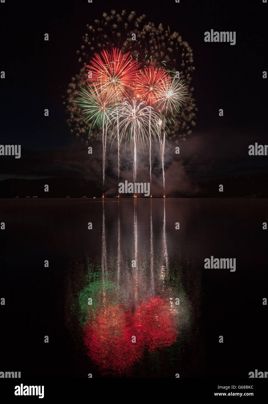 Colorful fireworks with reflection on lake and night sky in background ...