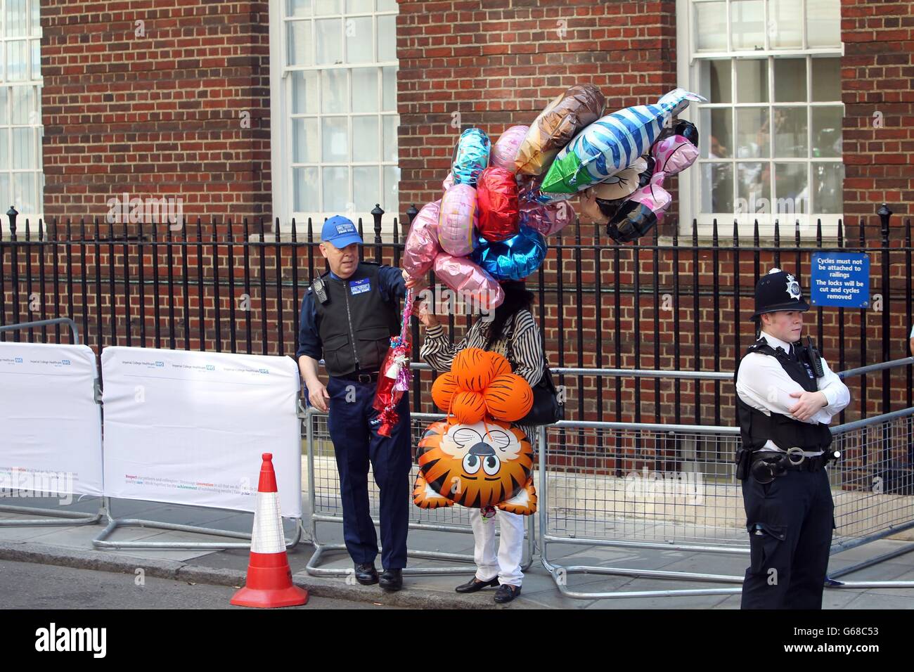 Police remove balloons from a barrier outside the Lindo Wing of St Mary ...