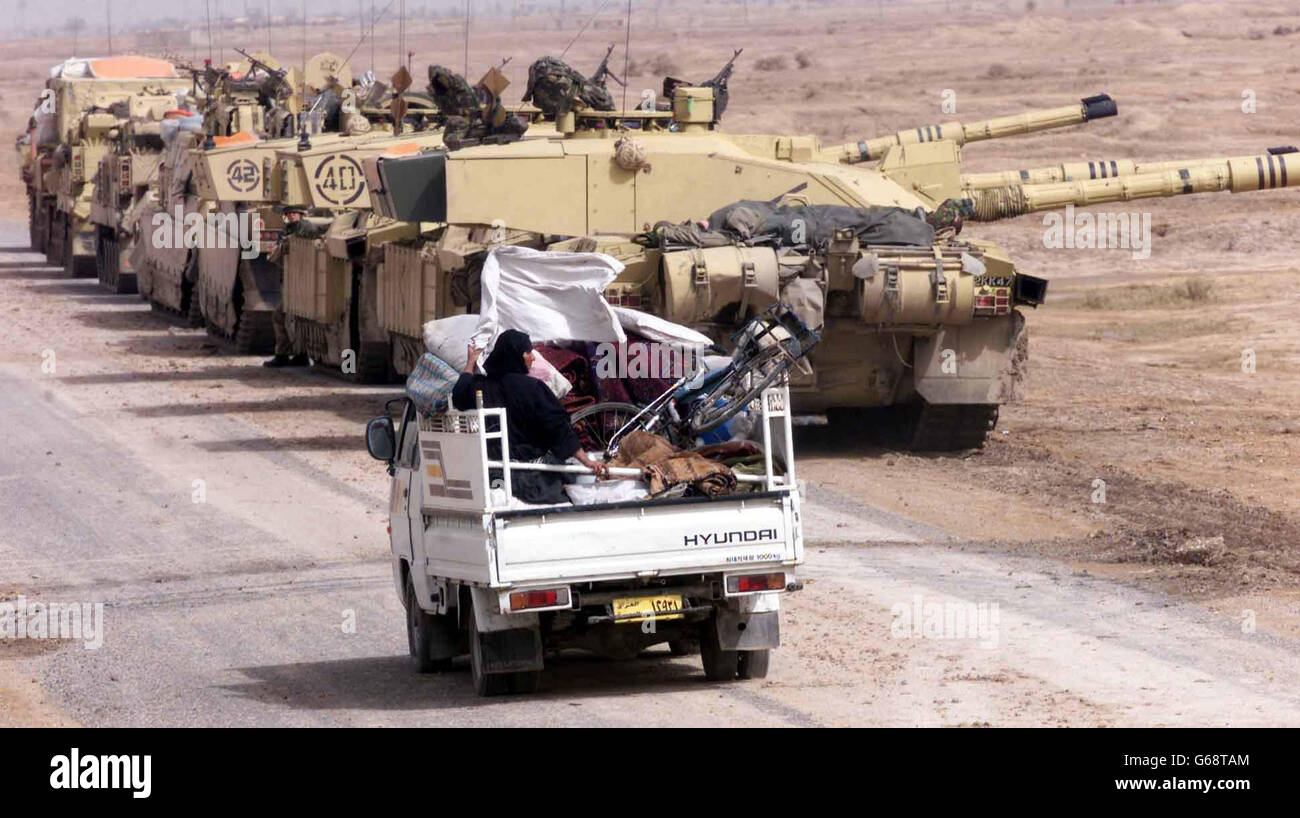 An Iraqi woman waves the white flag as she passes Challenger II tanks ...