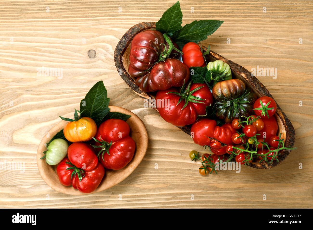 Biodiversity. Fresh heirloom tomatoes on wooden table. Flat lay, above ...