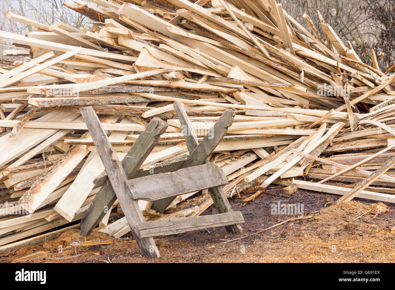Sawbuck on pile of firewood background Stock Photo - Alamy