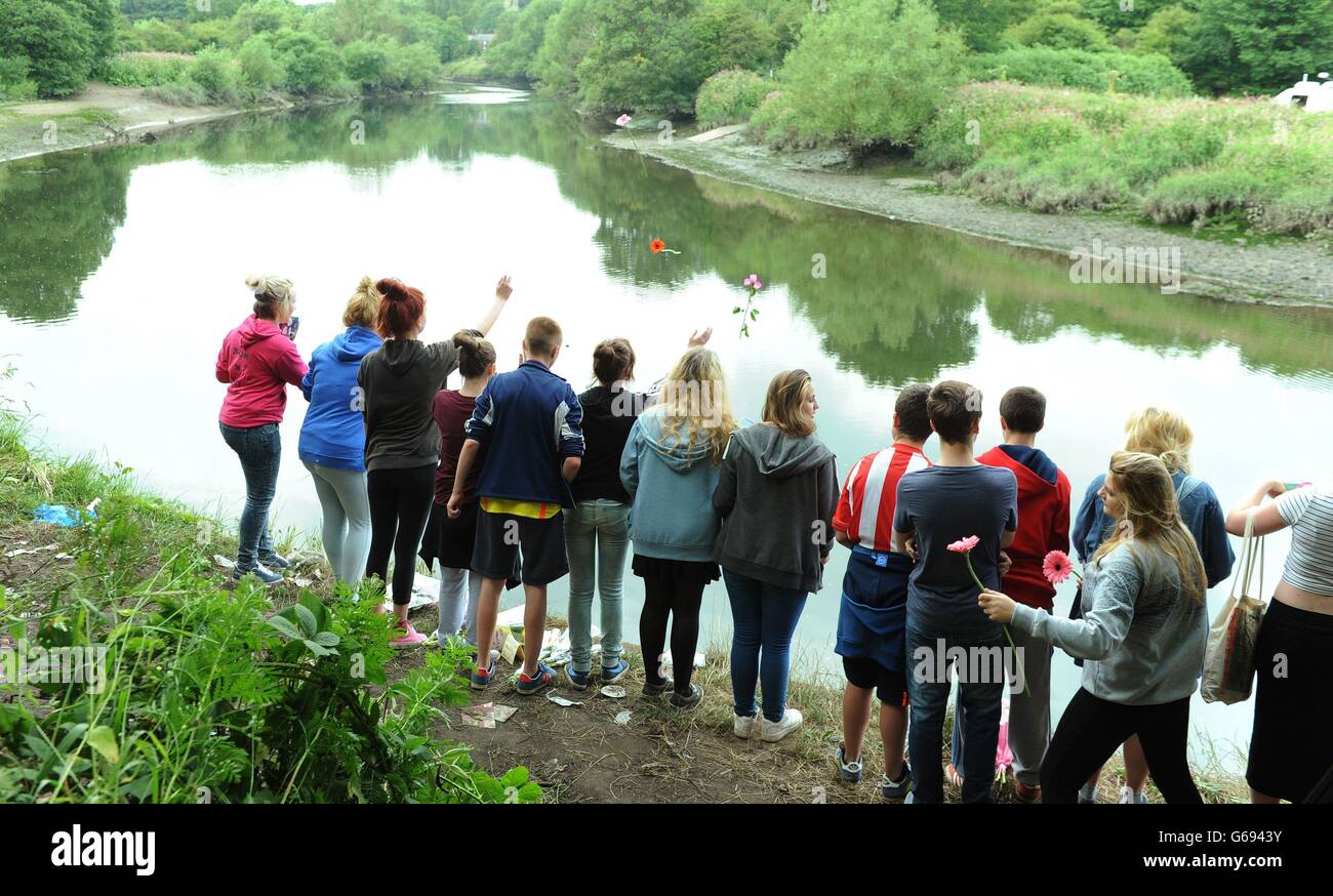 Friends of the two teenagers who drowned throw flowers in the river ...