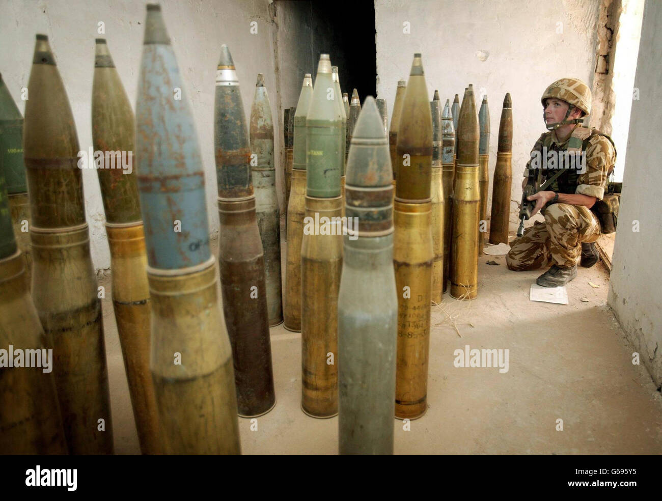 Some British soldiers guarding ammunition left at an abandoned Iraqi ...