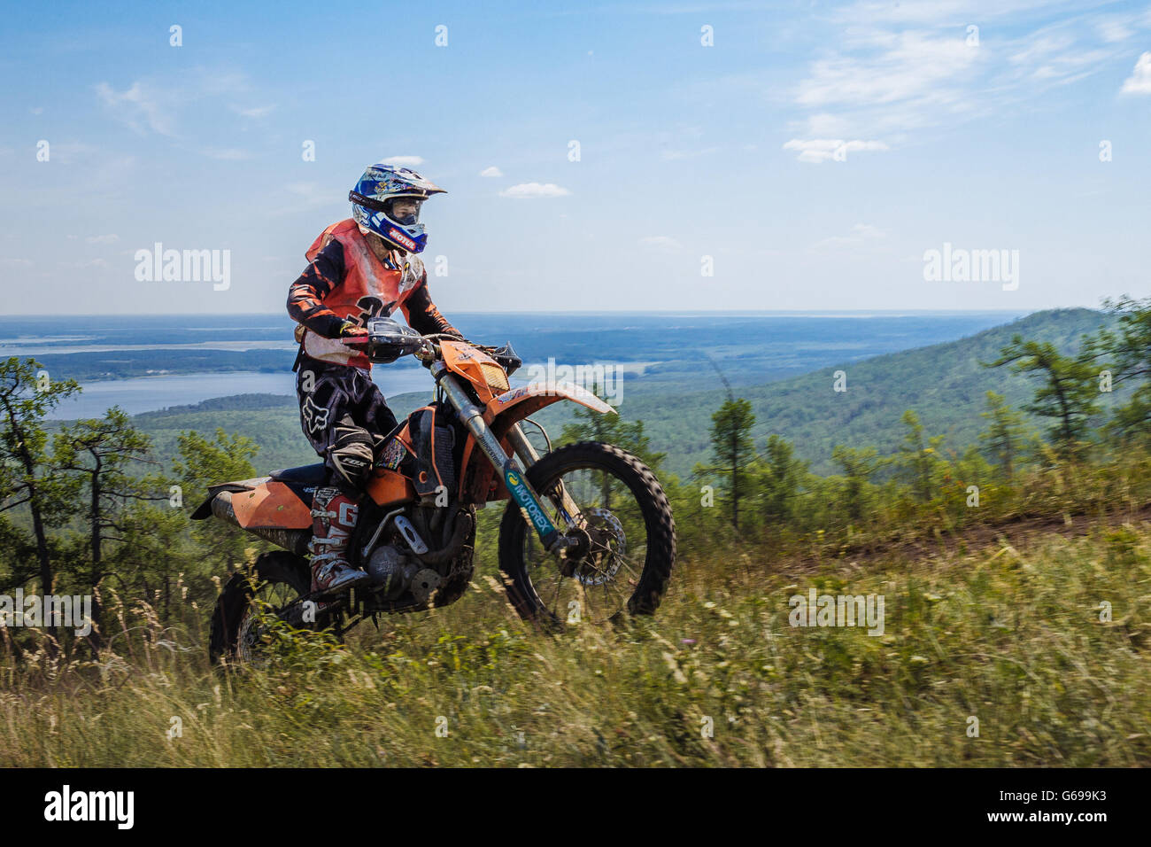 athlete motorcyclist riding on mountain in background of mountains and ...