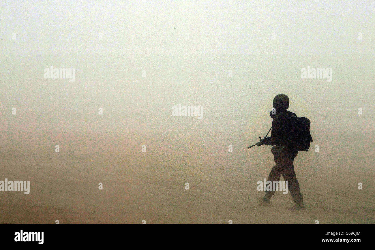 A British soldier patrols during a sandstorm in the Kuwaiti desert ...