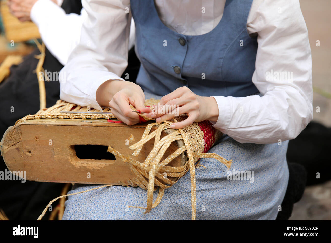 young girl with tapering fingers of the hand creates patiently a straw ...