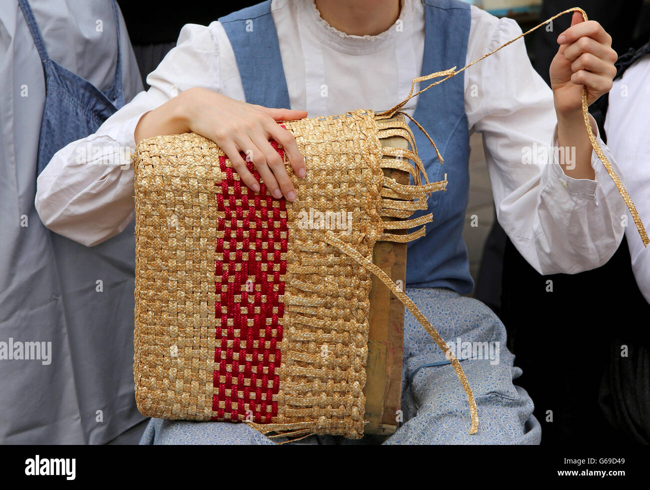 young woman with tapering fingers of the hand creates patiently a straw ...