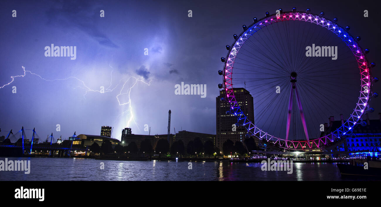 Lightning strikes behind The London Eye in London, which is coloured ...