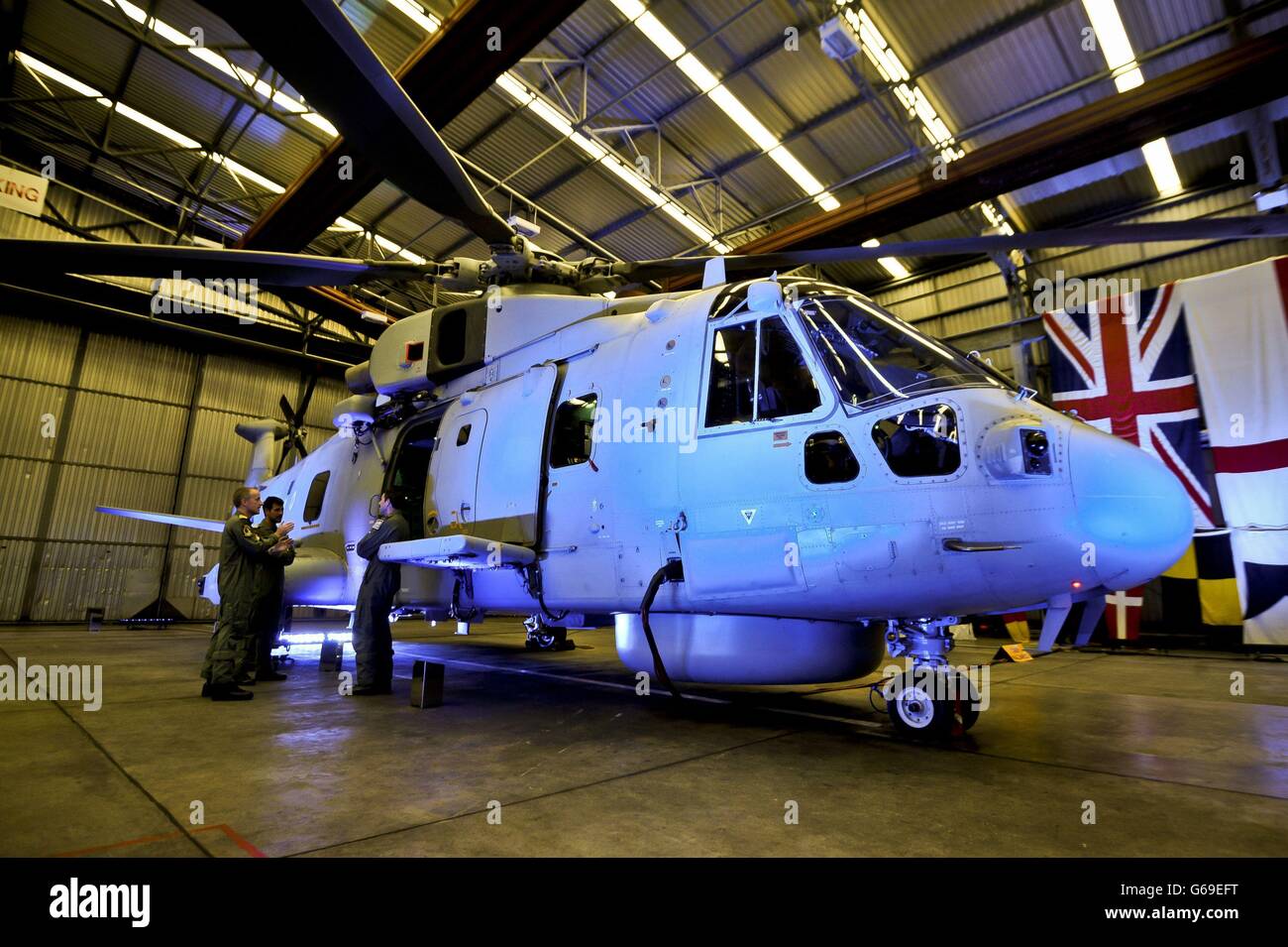 Aircrew beside a Merlin Mk 2 aircraft, which is on display in a hangar ...