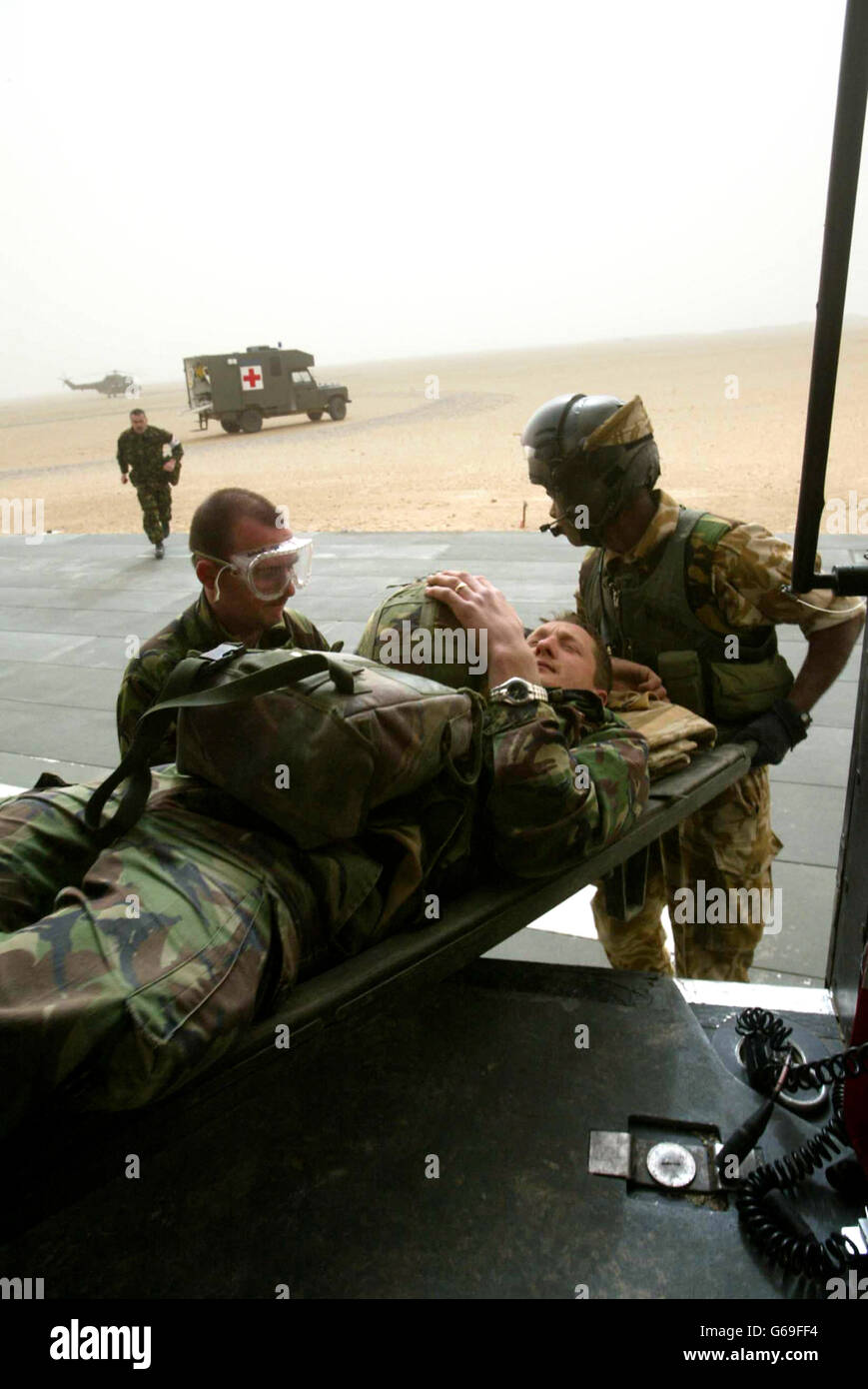 A british soldier clutches his helmet as he is medically evacuated of a ...