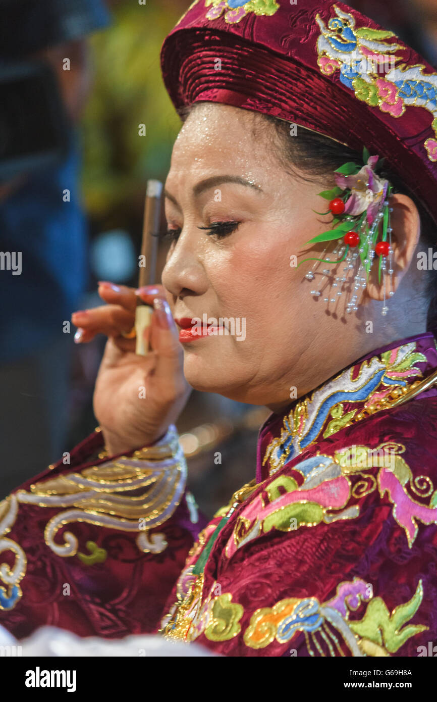 Female medium smokes while preparing for spirit mediumship ritual in ...