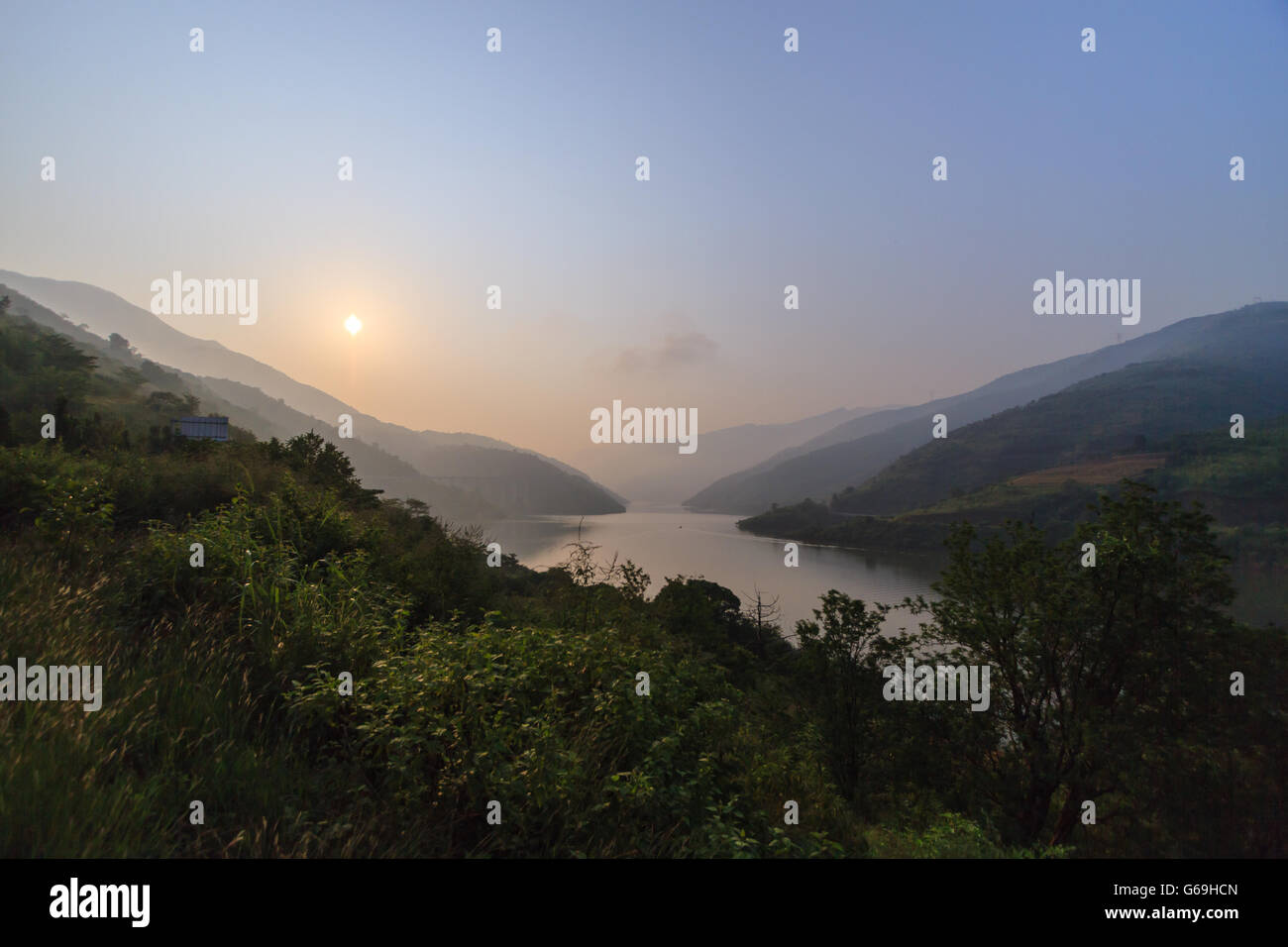 Lush vegetation, mountains and lake at sunrise in southern Yunnan ...