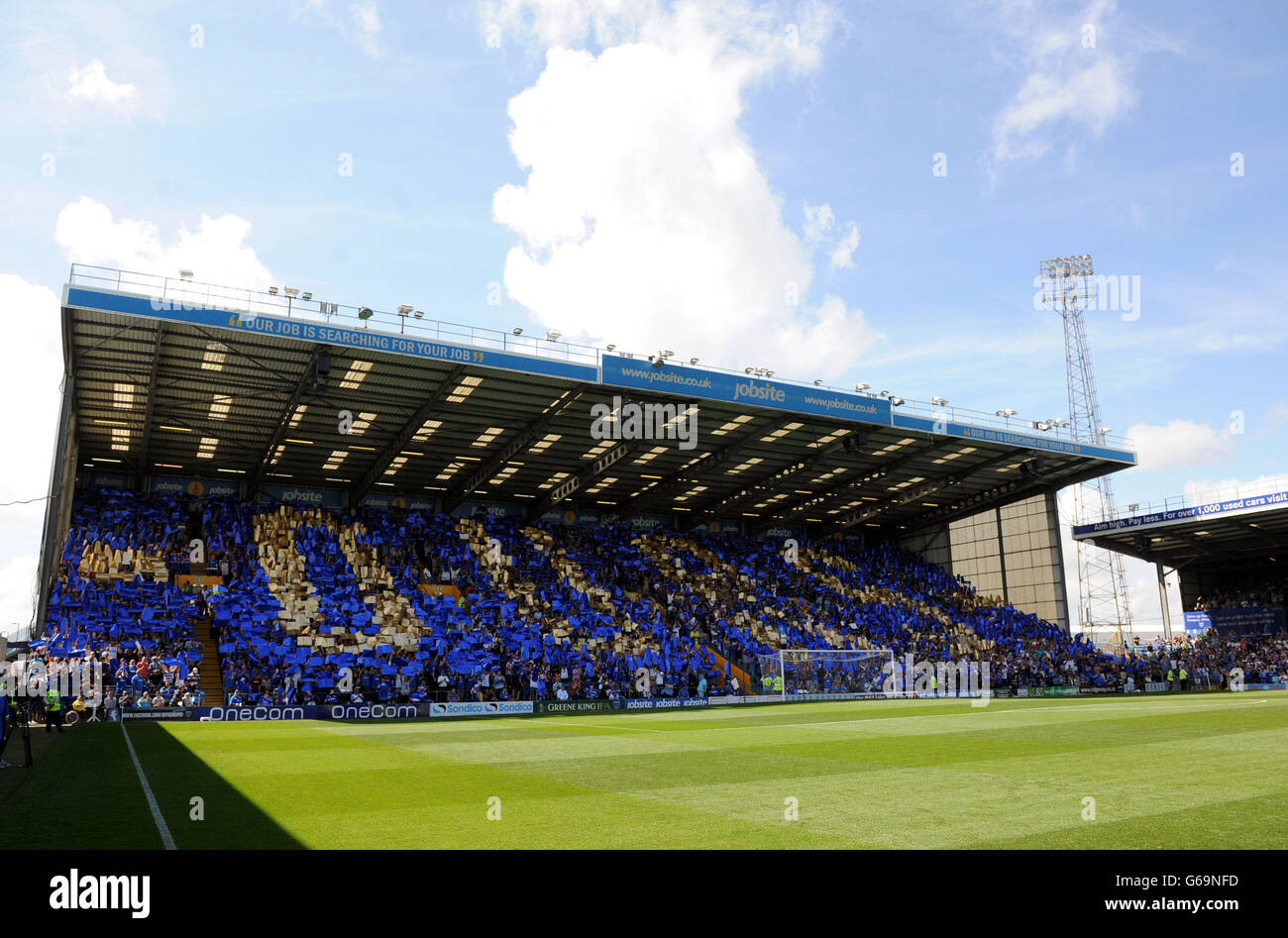 Portsmouth fans in the Fratton End stand hold up cards to display the ...