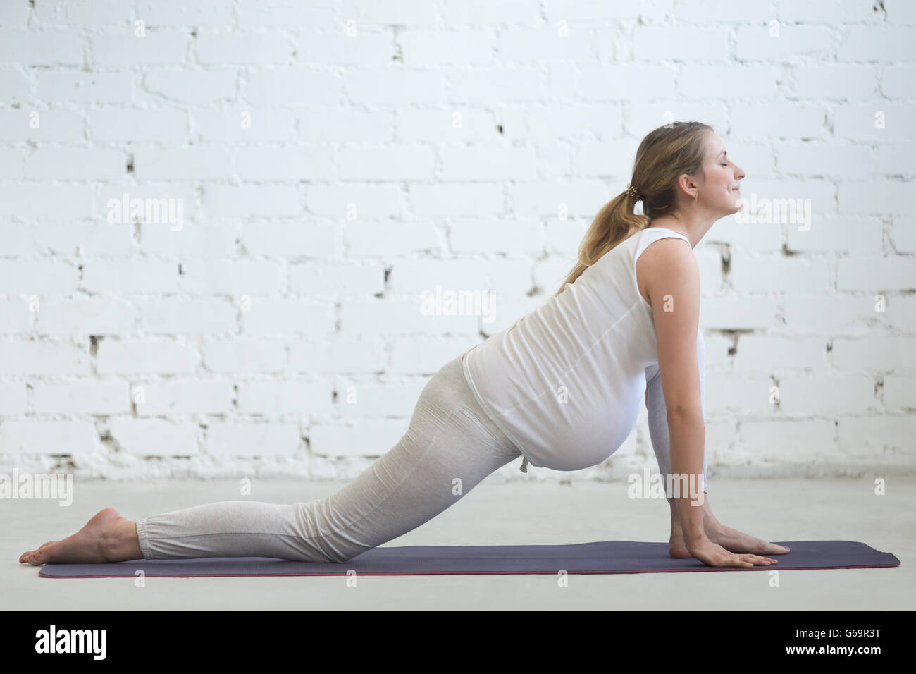 Pregnancy Yoga and Fitness. Young pregnant yoga model working out in ...