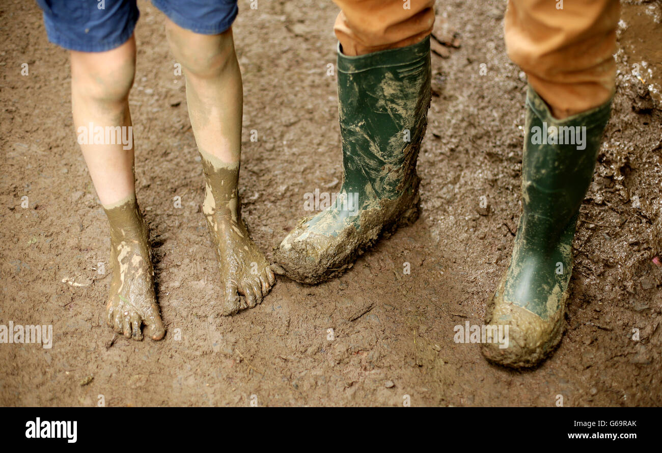A father and his son who is barefoot in the mud at the Glastonbury ...
