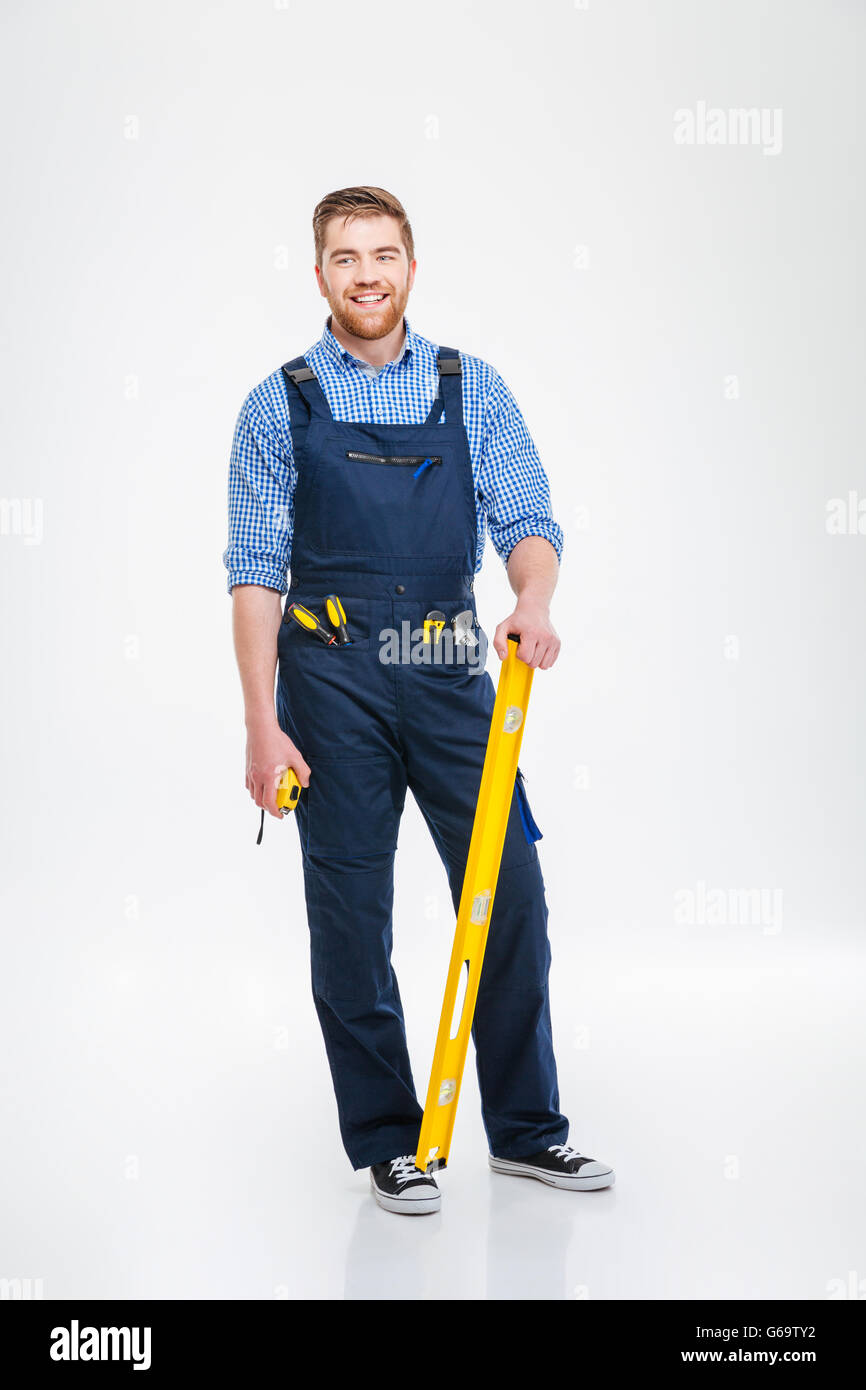Full length portrait of a smiling male builder standing isolated on a ...
