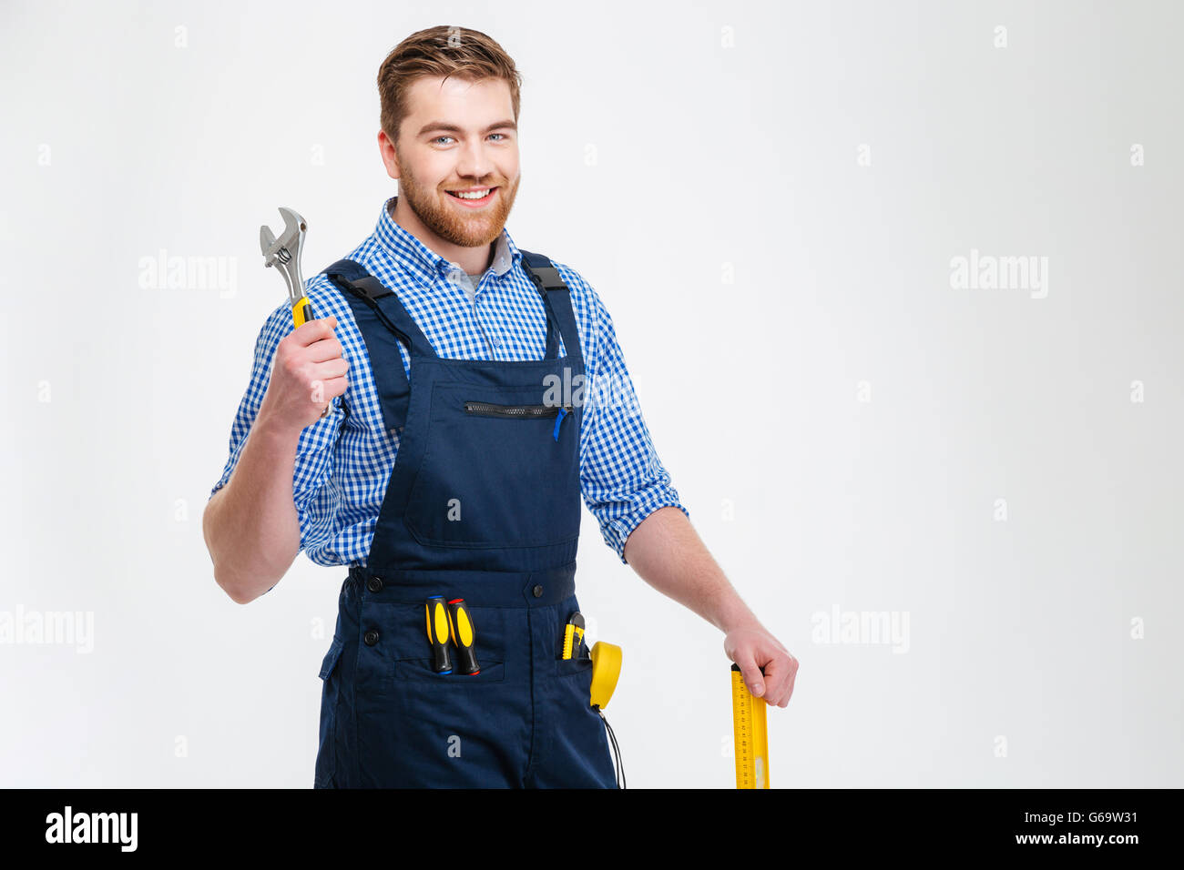 Portrait of a smiling male builder standing with equipment isolated on ...