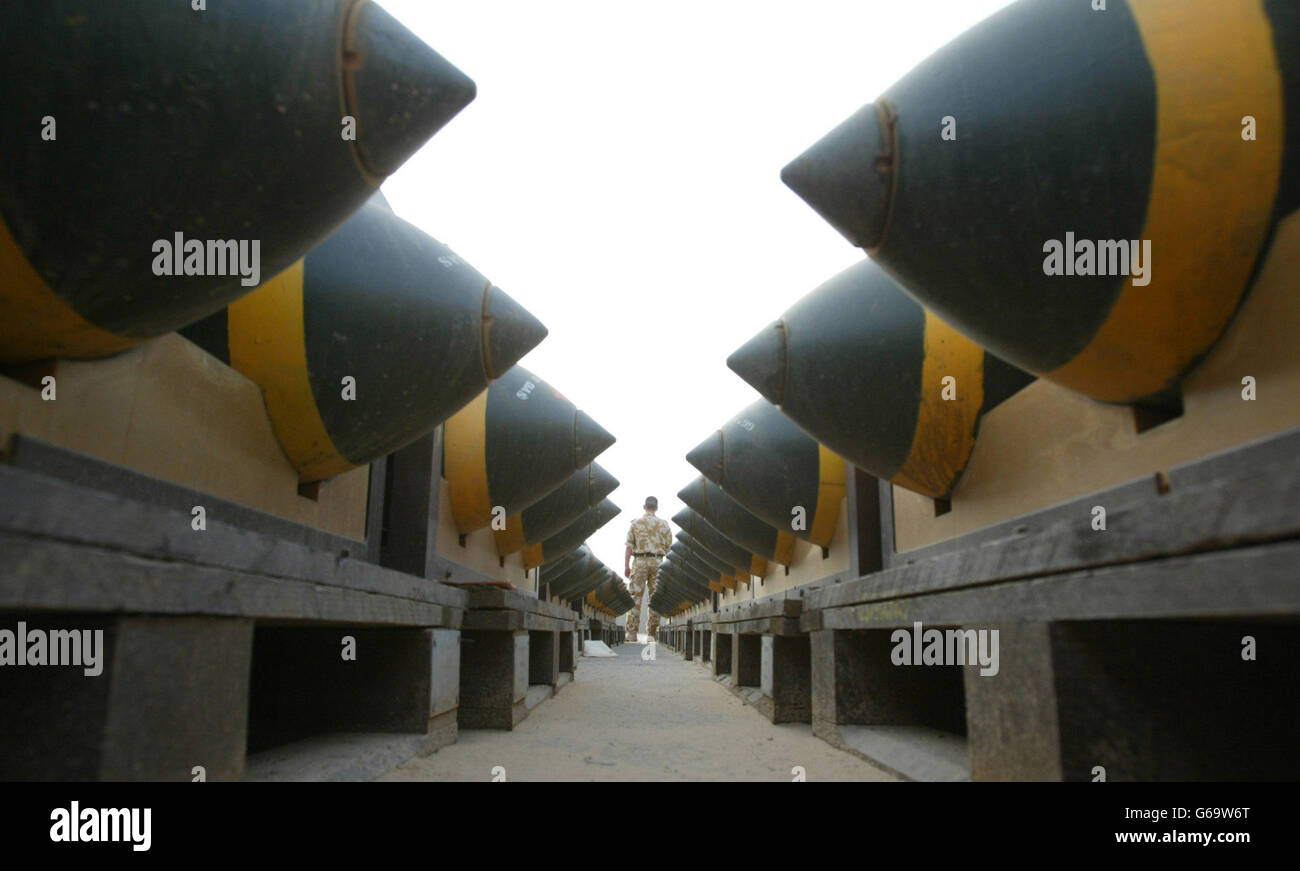A British Royal Air Force weapons technician walks past rows of ...