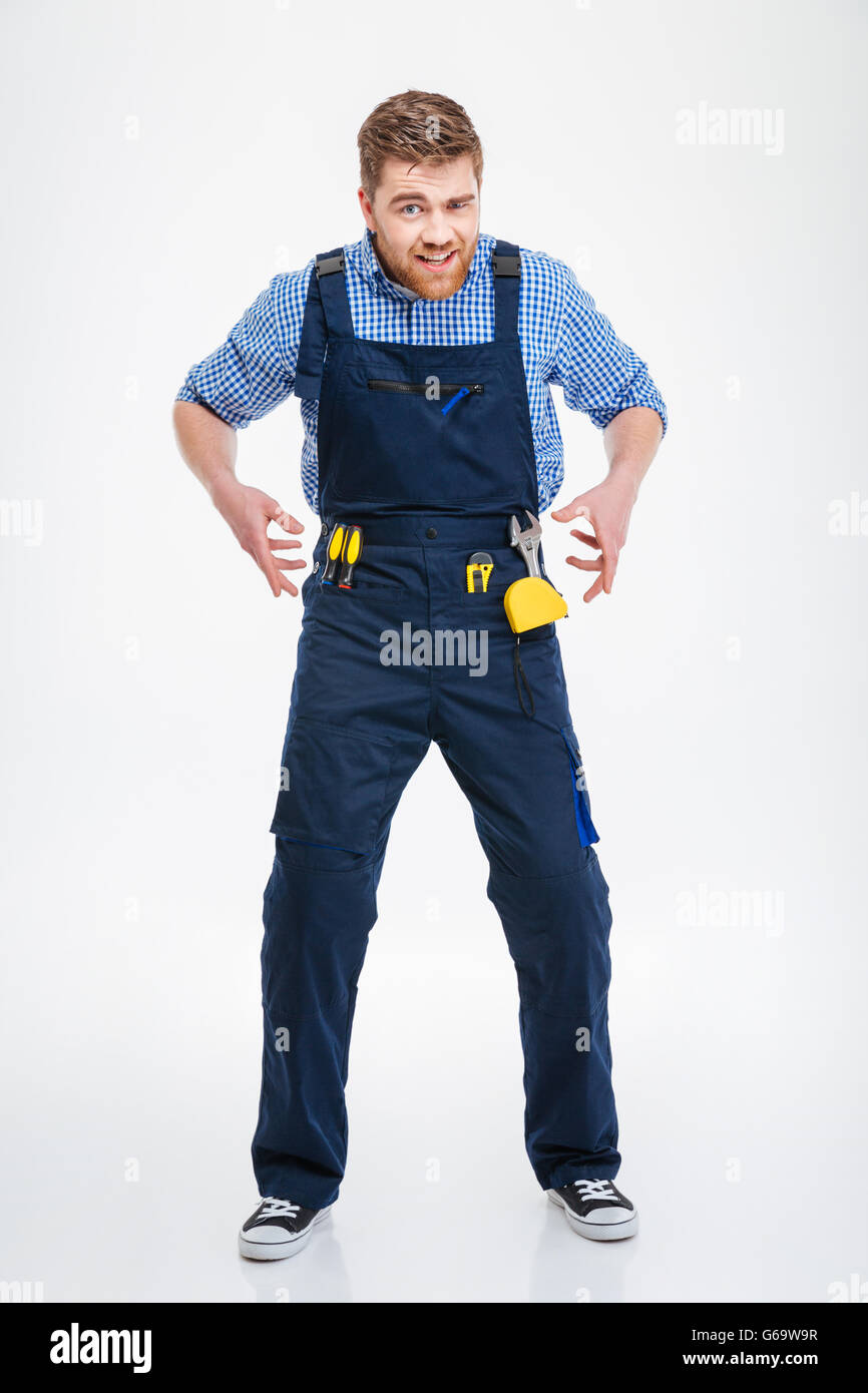 Full length portrait of a funny male builder standing isolated on a ...