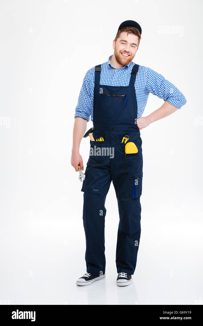 Happy handsome repairman in overall and cap standing and smiling Stock ...