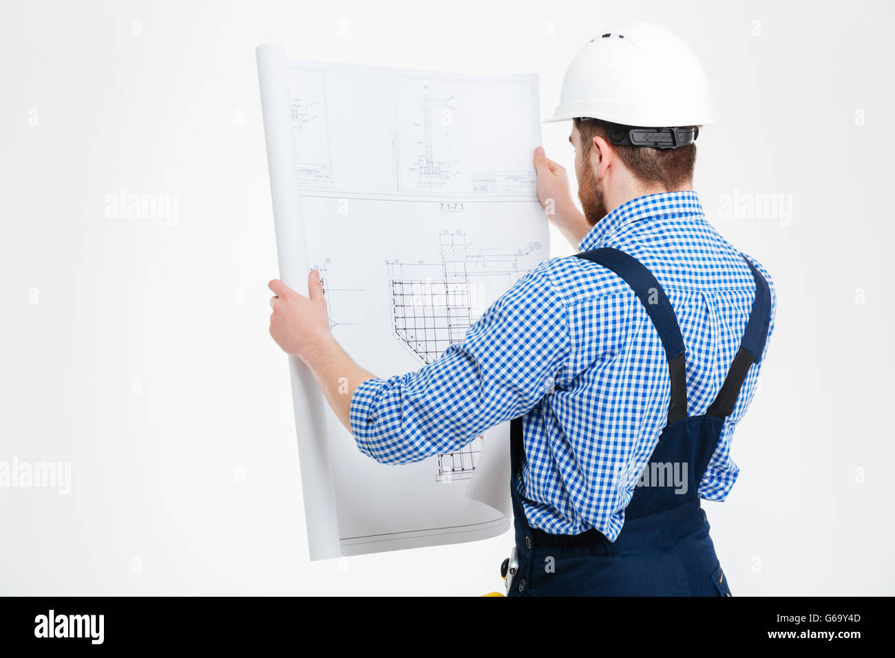 Back view of man builder in helmet working with blueprint Stock Photo ...