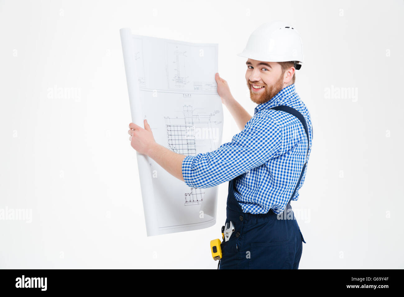 Cheerful attractive builder in helmet working with blueprint and ...