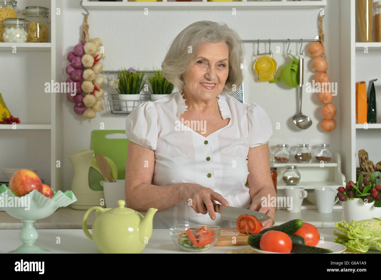Senior woman cooking in kitchen Stock Photo - Alamy