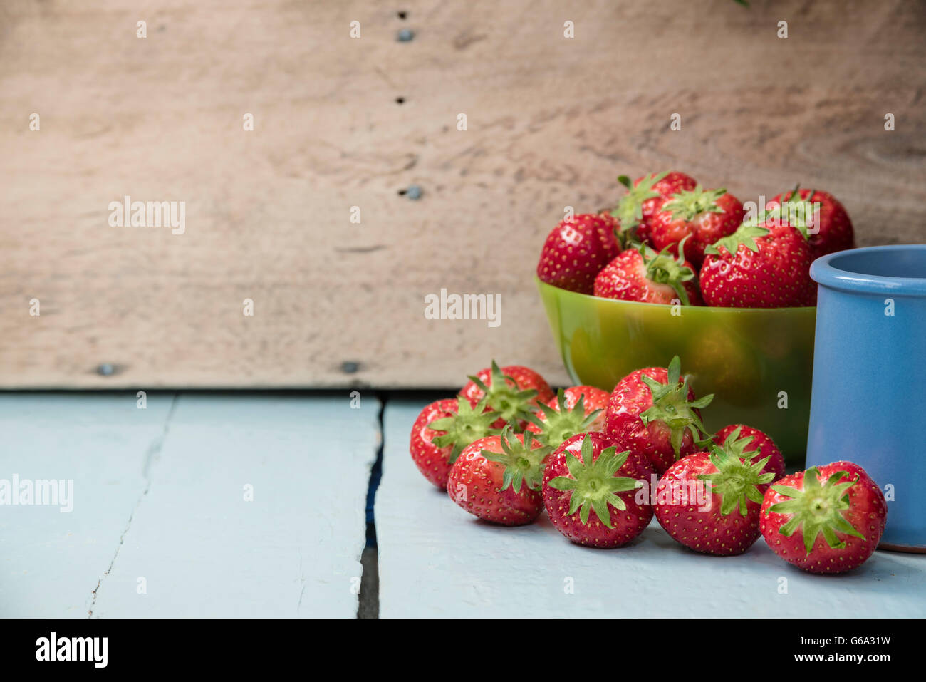 Scattered strawberry fruits in green bowl Stock Photo - Alamy