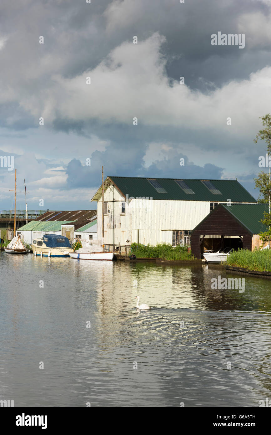 A boat yard at Ludham Bridge the Norfolk Broads UK withrain clouds ...