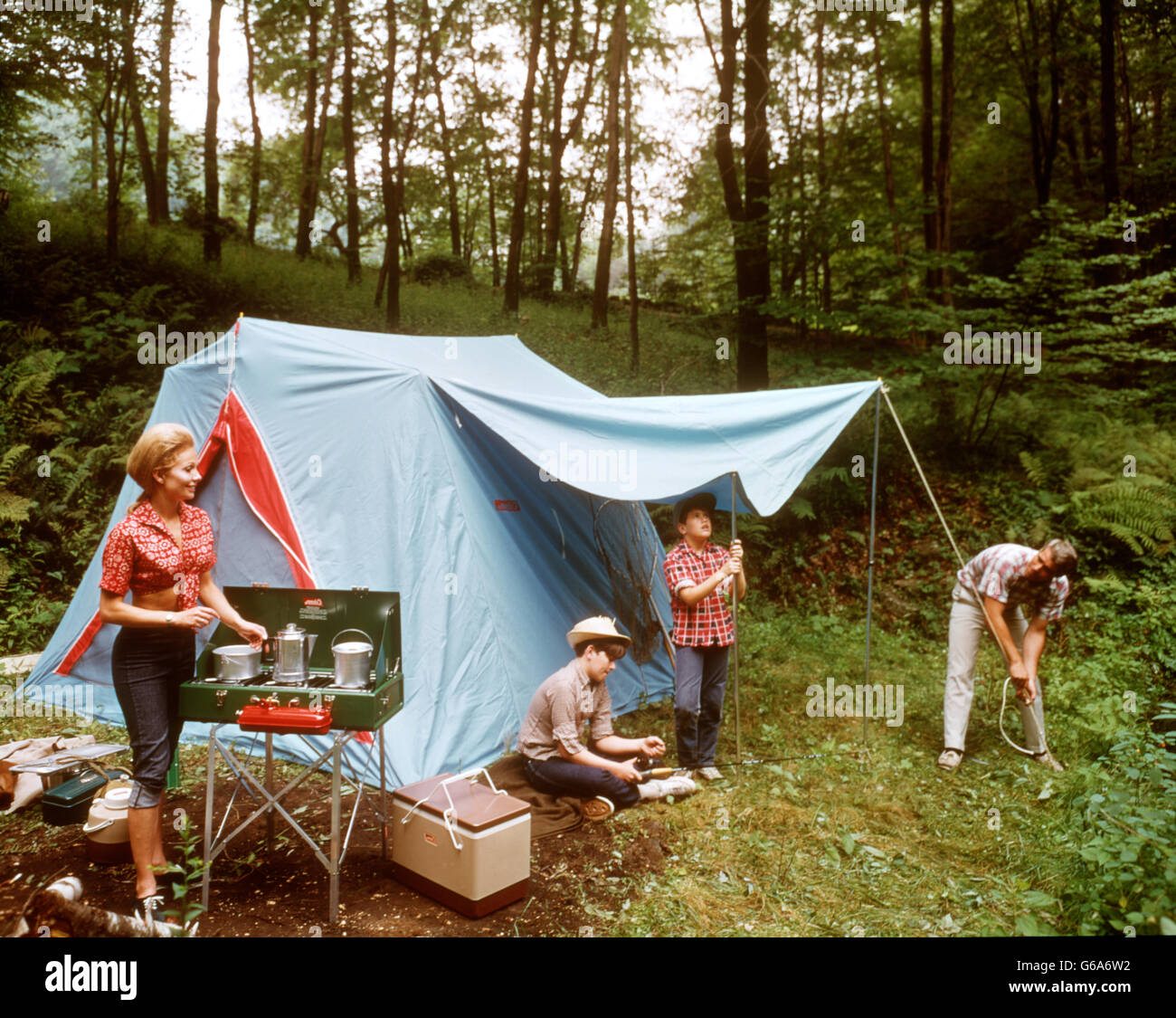 1970s FATHER 2 PRETEEN BOYS SETTING UP TENT CAMPSITE MOTHER COOKING ...